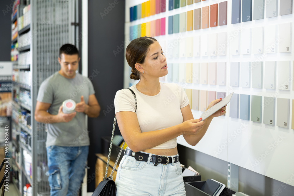 Stock-Foto „Positive young female designer picking paint colors for ...