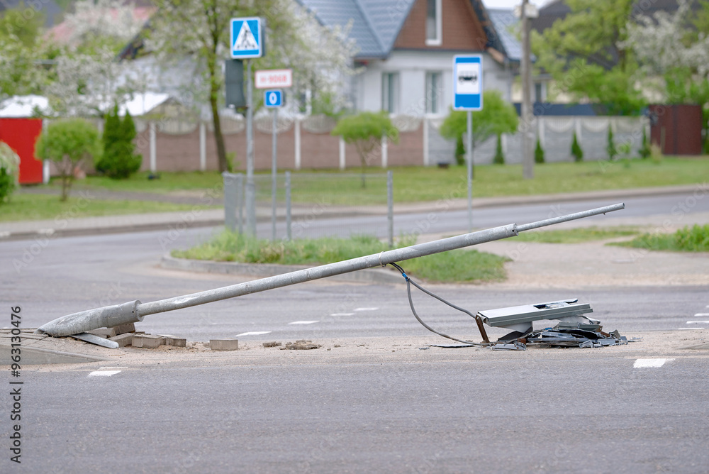 Foto de Stock Damaged traffic light pole lies broken on the road at ...