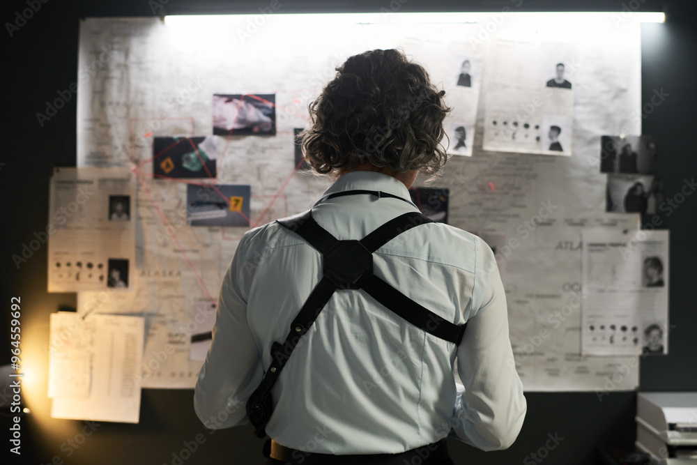 Person wearing white shirt and harness examining large map with crime ...