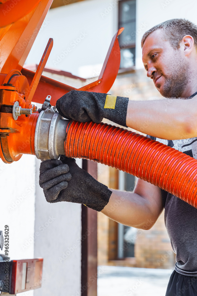 Photo Stock man connects a suction hose to a sewage tanker truck. Sewer ...