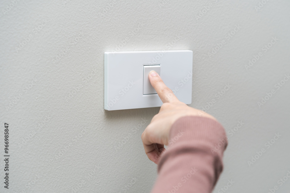 Close up of hand of woman turn off on lighting switch at home room ...