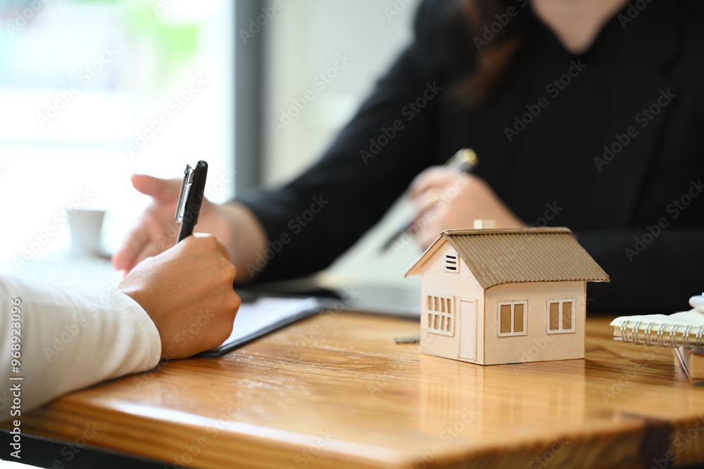 Realtor in suit pointing at contract document to client put a signature ...