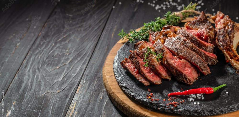 sliced rib eye Tomahawk beef veal steak on a dark background. top view ...