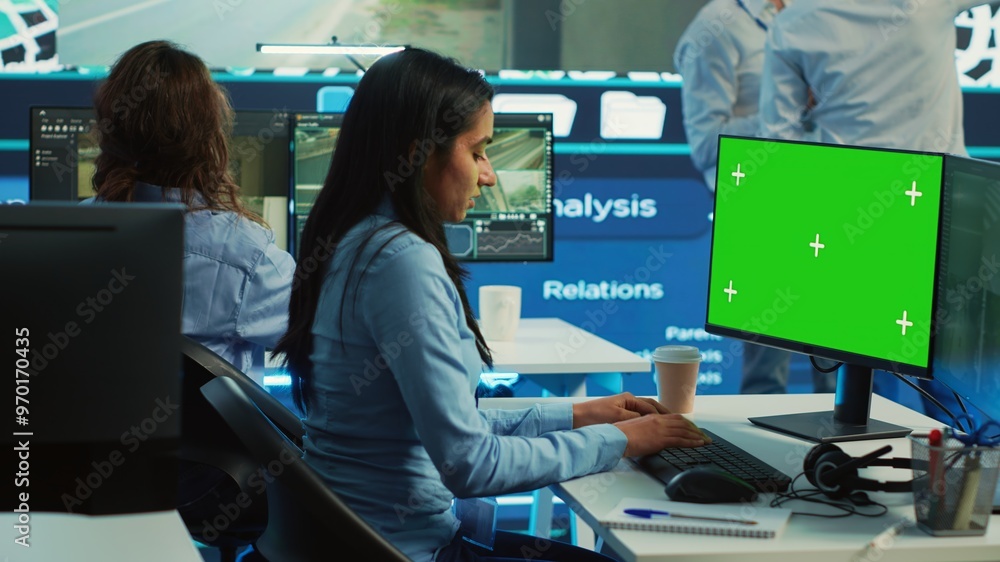 Indian employee follows order shipment next to a greenscreen on pc ...