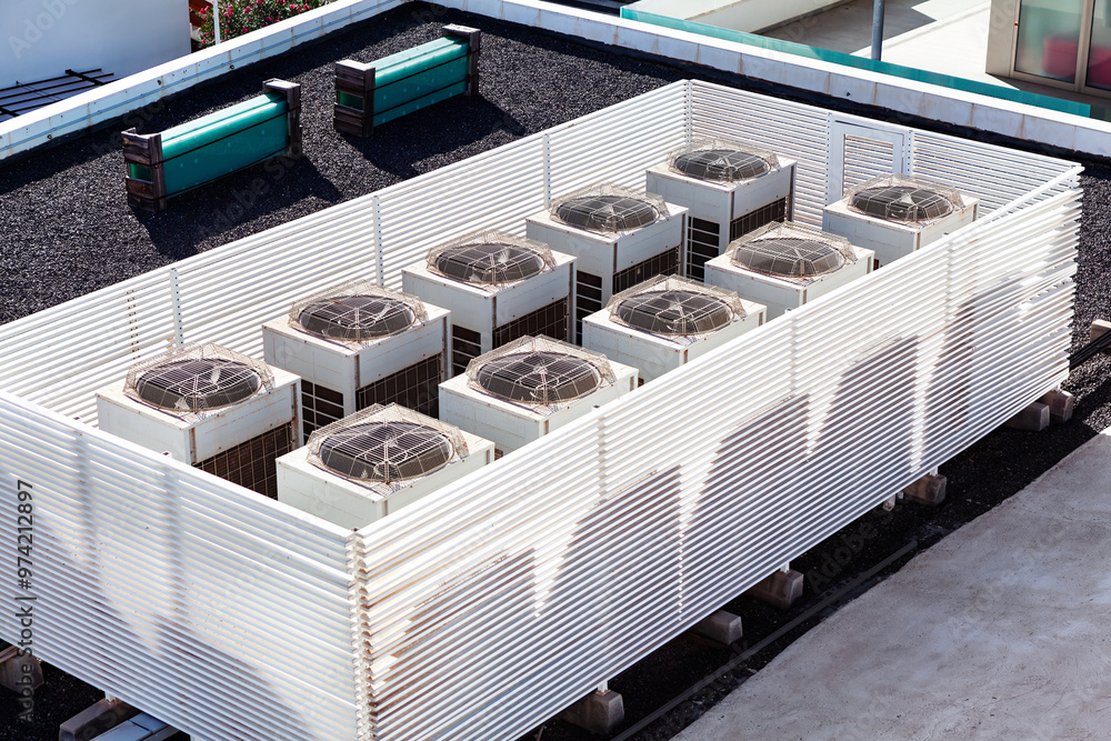 Row of air conditioners are on a roof. Multiple air conditioning units ...