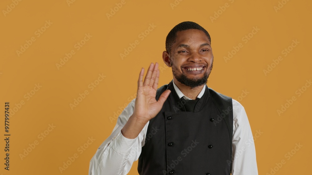 Skilled waiter waving and greeting clients at five star restaurant ...