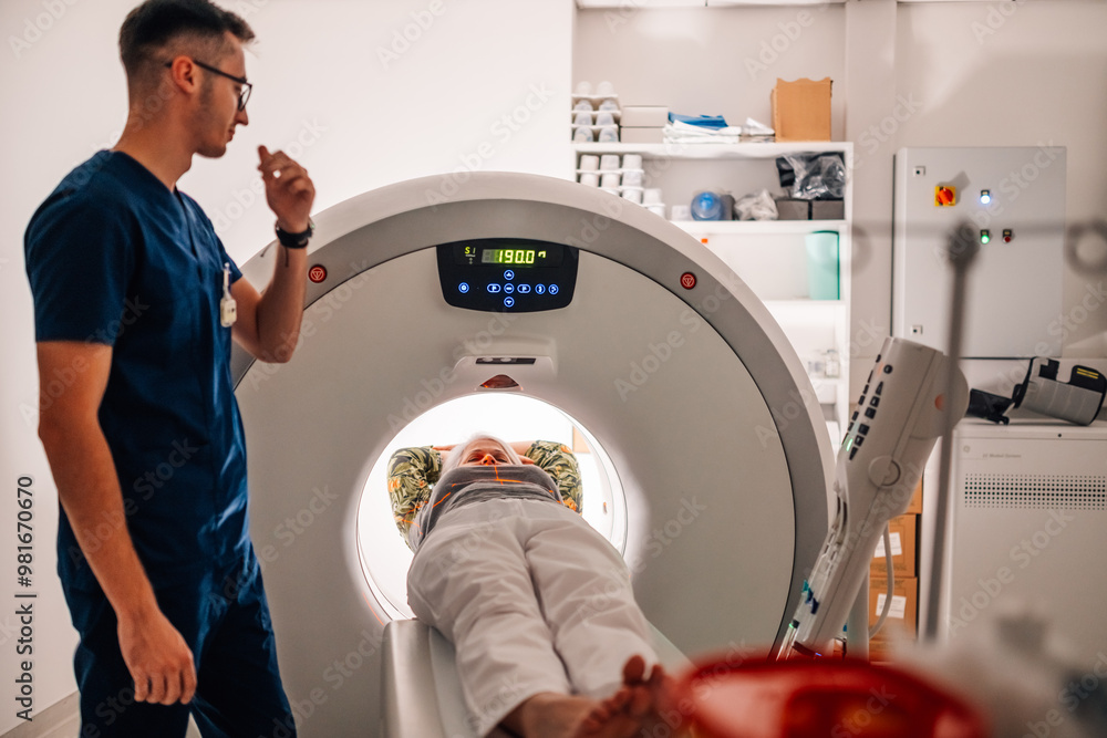 High-tech CT scan machine operating with patient in hospital room ...
