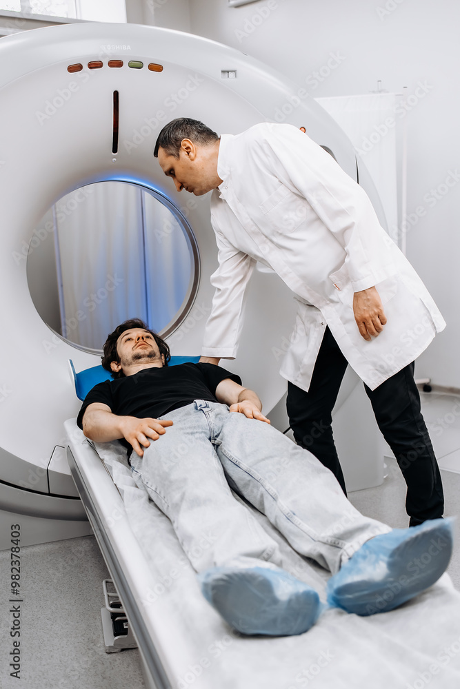 In a modern diagnostic center, a young male patient undergoes an MRI or ...