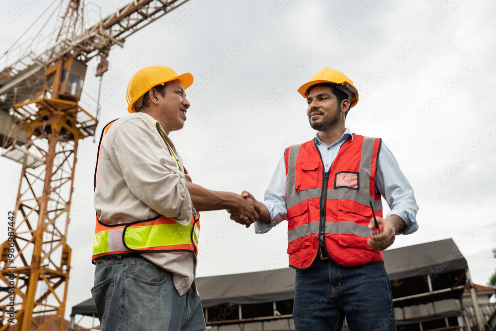 Asia engineer man worker hand shake with India engineer man with crane ...