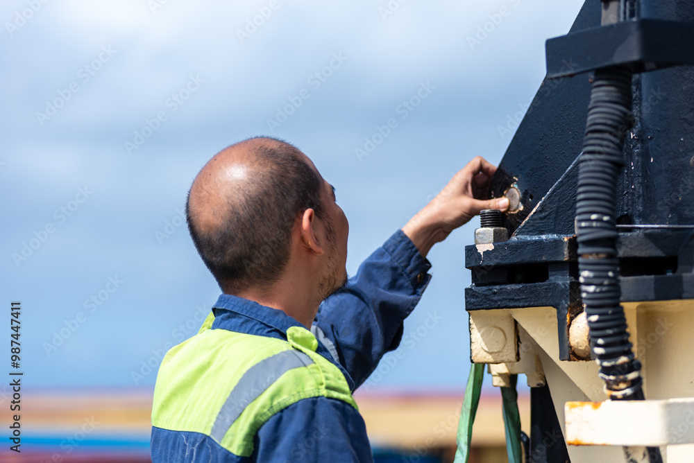 An engine officer conducting a routine inspection of deck equipment ...