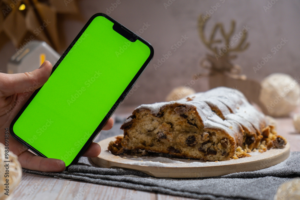 Christmas Stollen in Christmas lights and decoration. Smartphone with ...