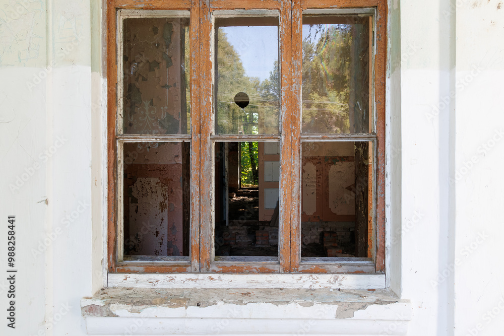Old wooden window frame with peeling paint and broken glass. The ...