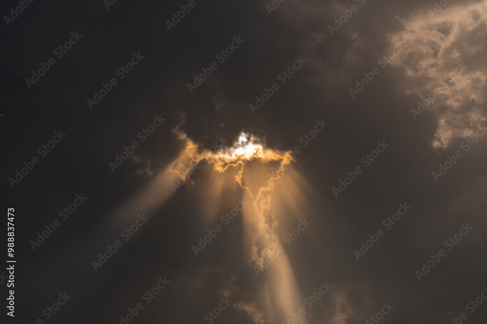 Sun rays coming out from the dense black rain clouds which makes beam ...