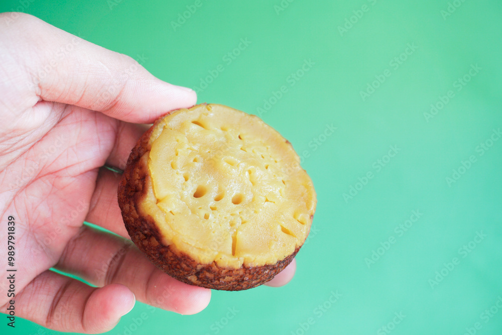 Hand holding Bika ambon or golden cake or golden kuih bingka in ...