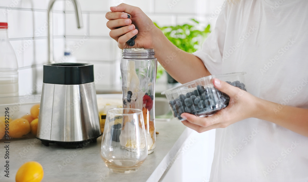 Little Girl Making A Fruit Shake Adding Blueberry And Raspberry To A ...
