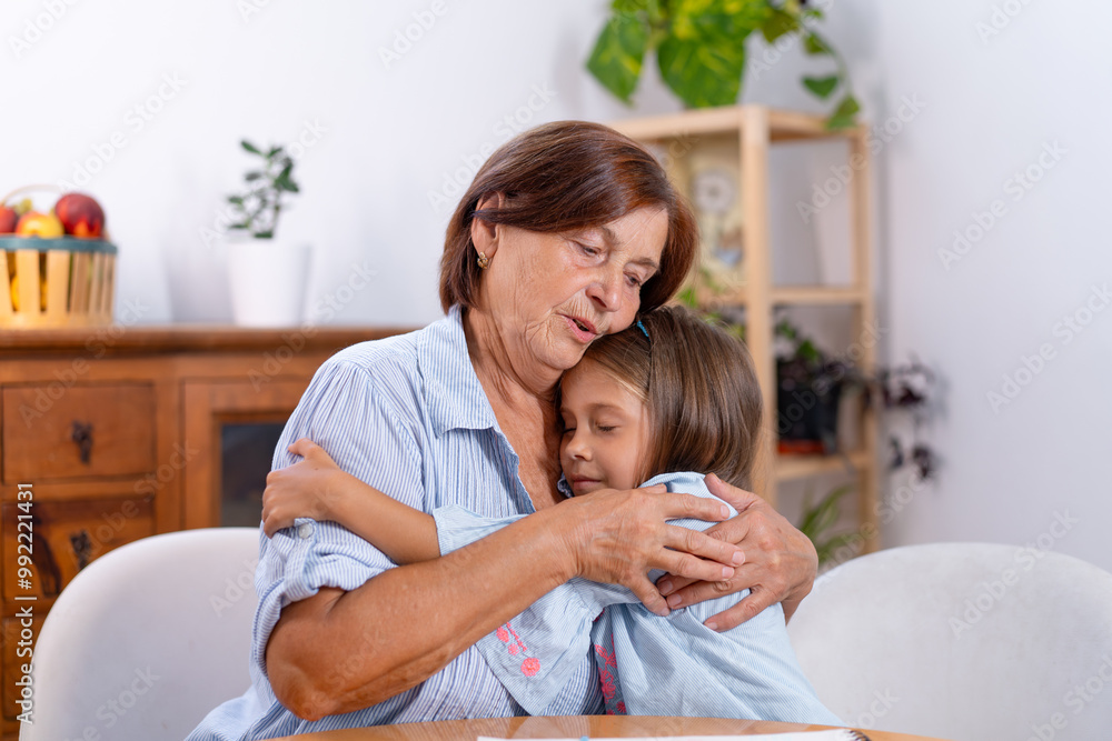 Cute loving girl embracing grandmother as they spending quality moment ...