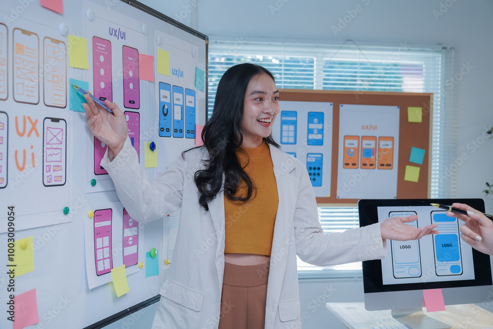 Young asian ui/ux designer is standing and presenting a mobile ...