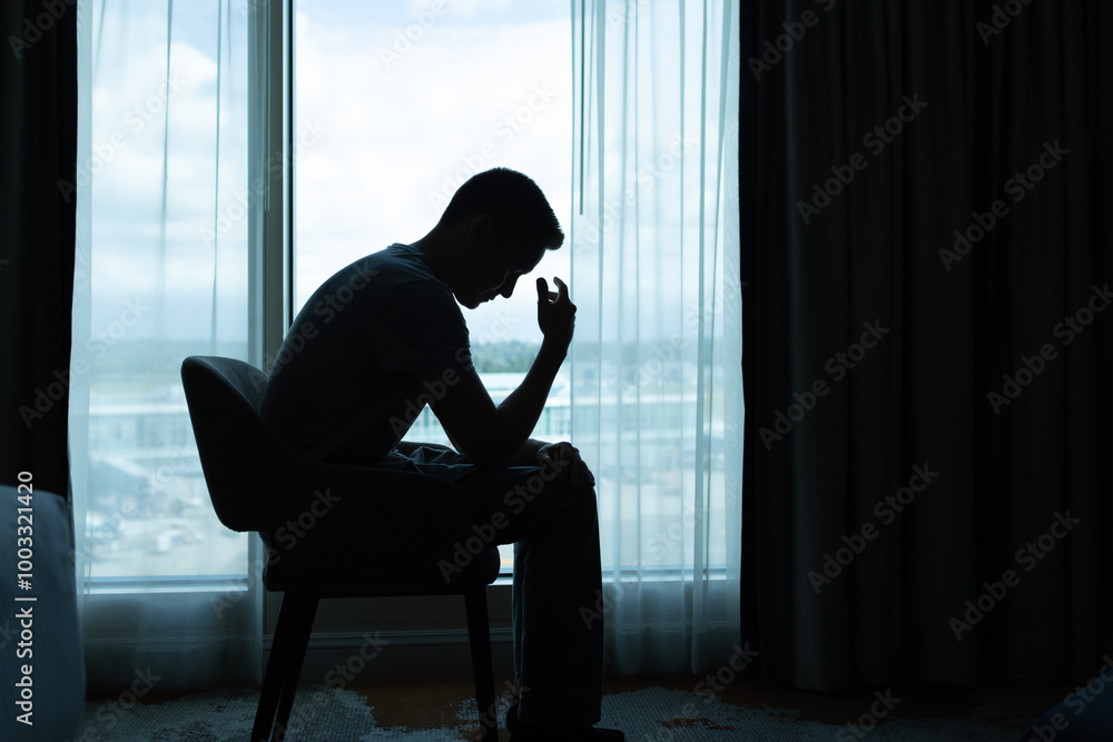 Sad man in a dark room full of desperation thoughts. Portrait of ...