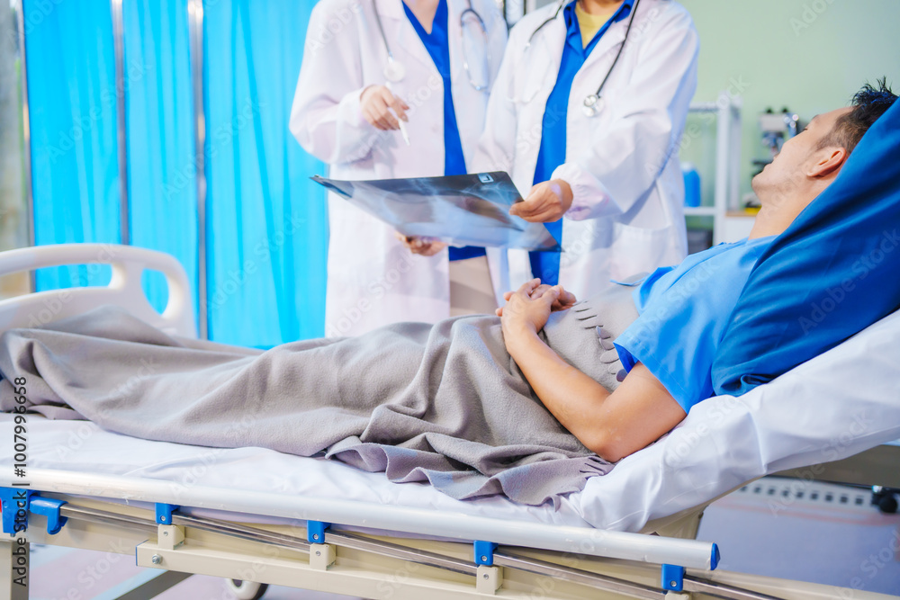A middle-aged man lies bedridden on hospital bed, closely monitored by ...
