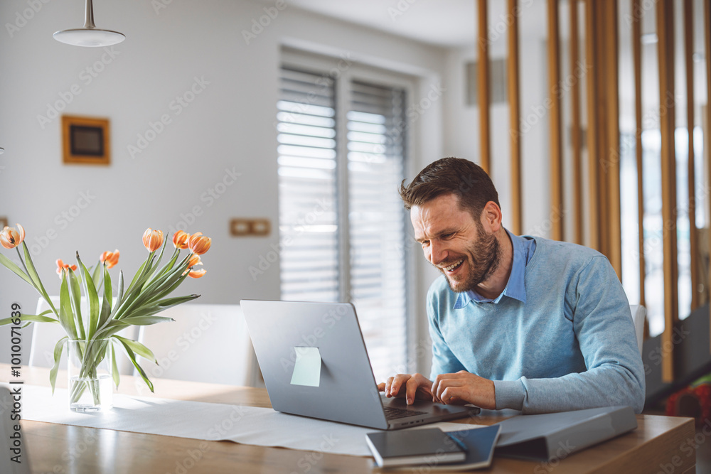 Excited man full of energy sitting behind laptop with big smile on his ...