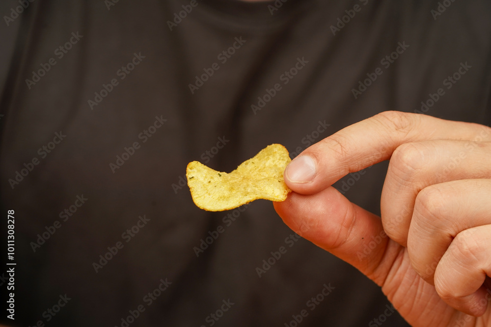 Hand holding potato chip closeup. Calories. Obesity. American food ...