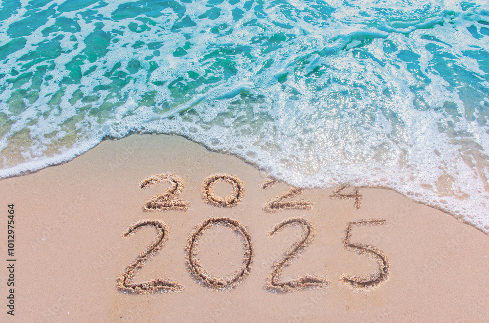 Message Year 2024 replaced by 2025 text written on beach sand ...
