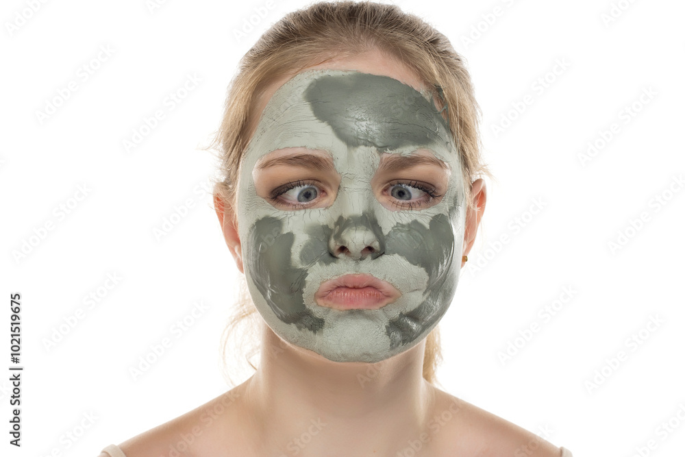 Funny young woman posing with a semmy-dried facial green mud mask on ...