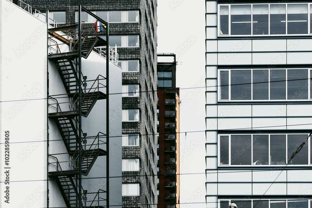 Fire escape ladders are attached to the side of an urban high-rise ...