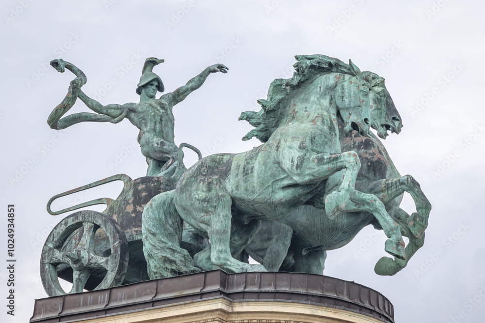 Statue of man holding a snake on a horse drawn chariot, Millenium ...
