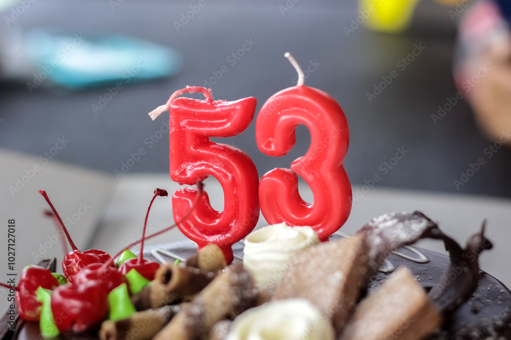 A beautifully decorated birthday cake with number 53 candles on top ...