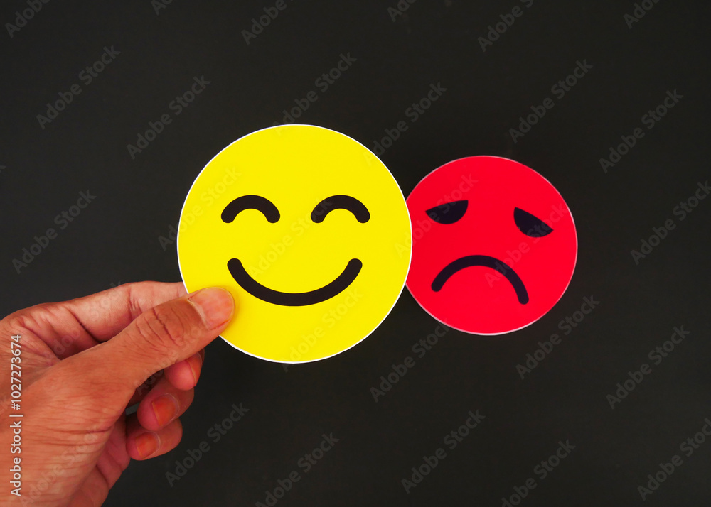 Hand holding card sad face hiding behind happy face. Concept of mood ...