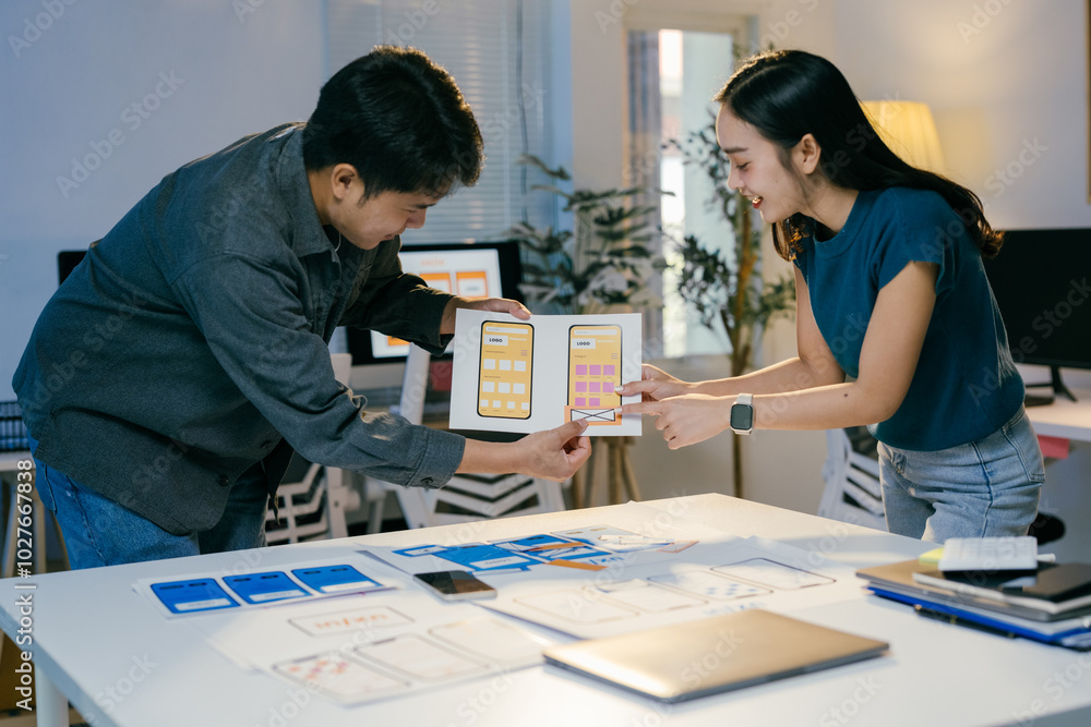 Two ui designers are discussing over a mobile app interface design ...