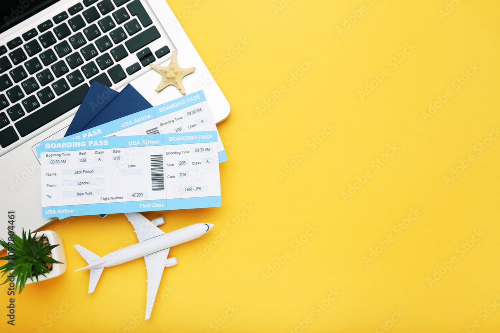 Airline boarding passes with passports, laptop, airplane model and ...