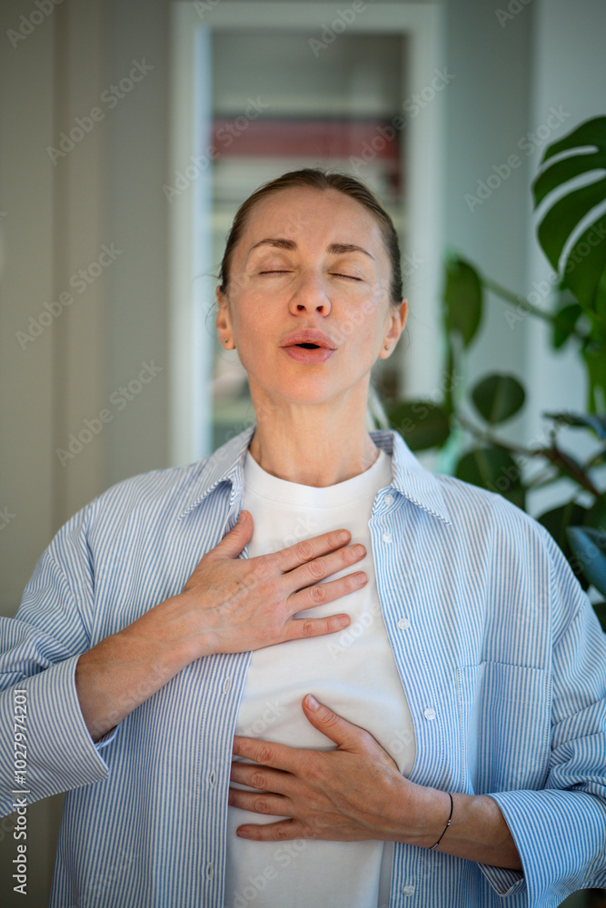 Calm middle aged woman practicing breathing meditation techniques ...