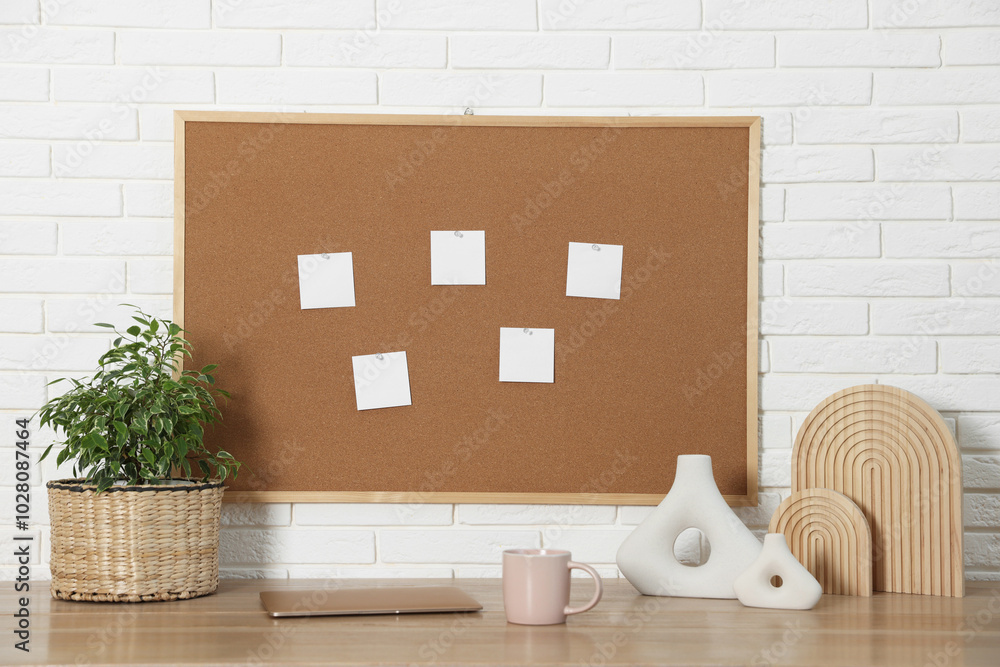 Cork board with blank paper notes, laptop and decorative elements on ...