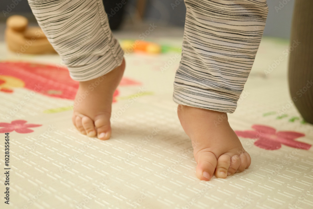 Unrecognizable baby's legs indoors barefoot with tender feet and toes ...