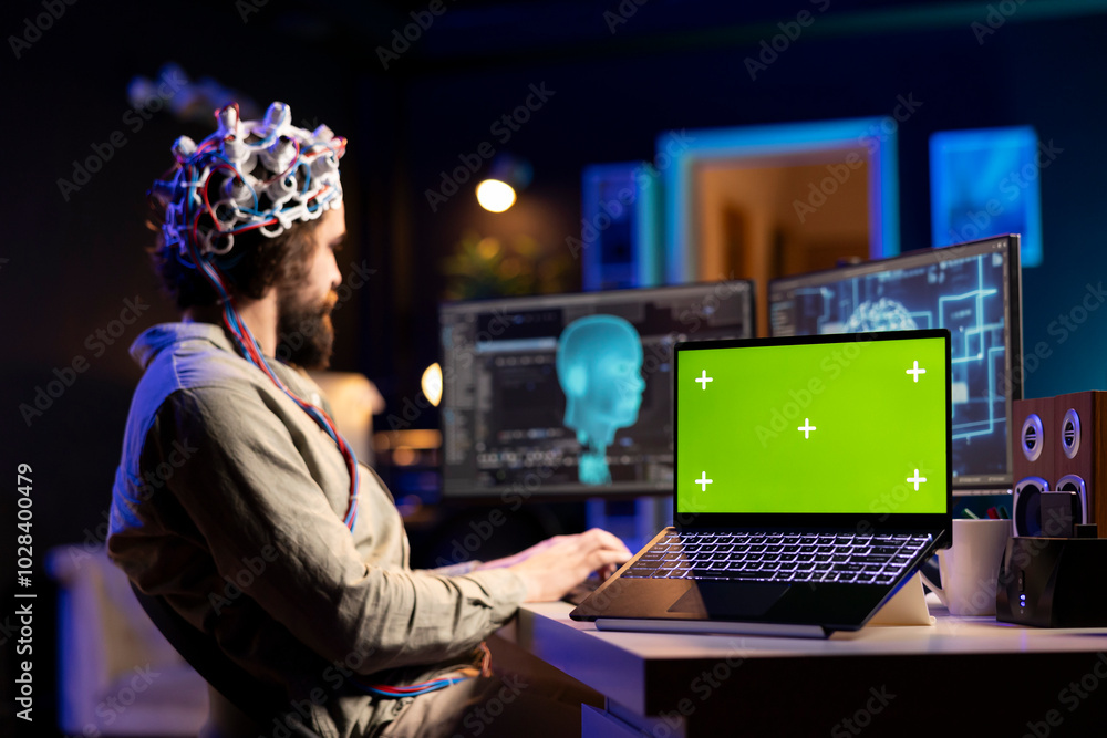 Focus on green screen laptop with man in blurry background using EEG ...