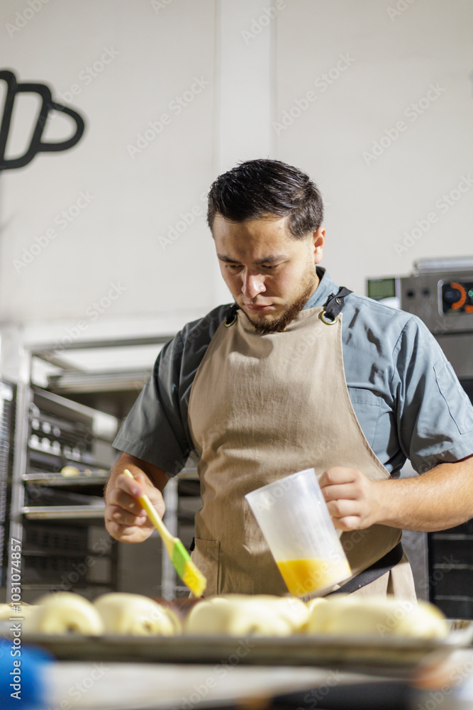 The Mexican baker expertly glazes the pan dulce with egg, carefully ...