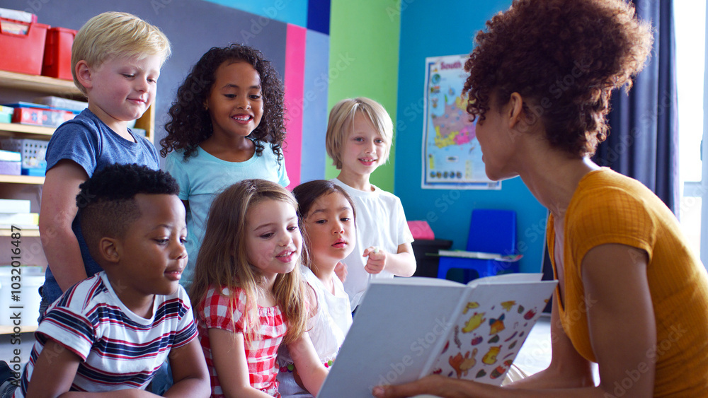 Group Of Elementary School Pupils Sitting On Floor Listening To Female ...
