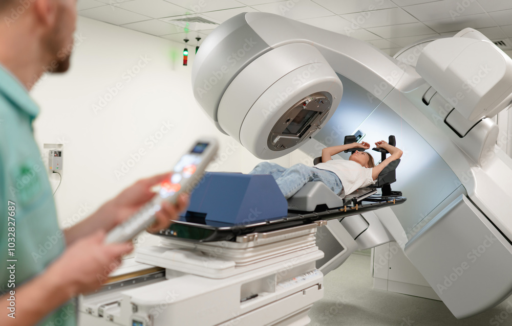 Patient lies on linear accelerator for radiotherapy, while medical ...
