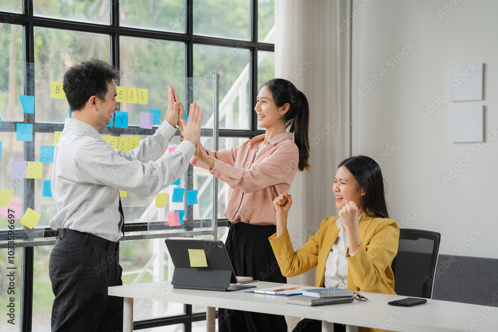 High Five for Success: A team of enthusiastic colleagues celebrates a ...