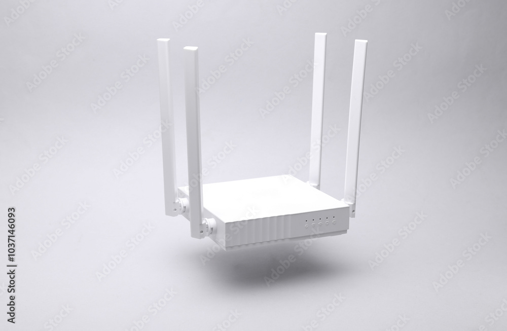 Modern white four-antenna wireless Wi-Fi router floating on gray ...