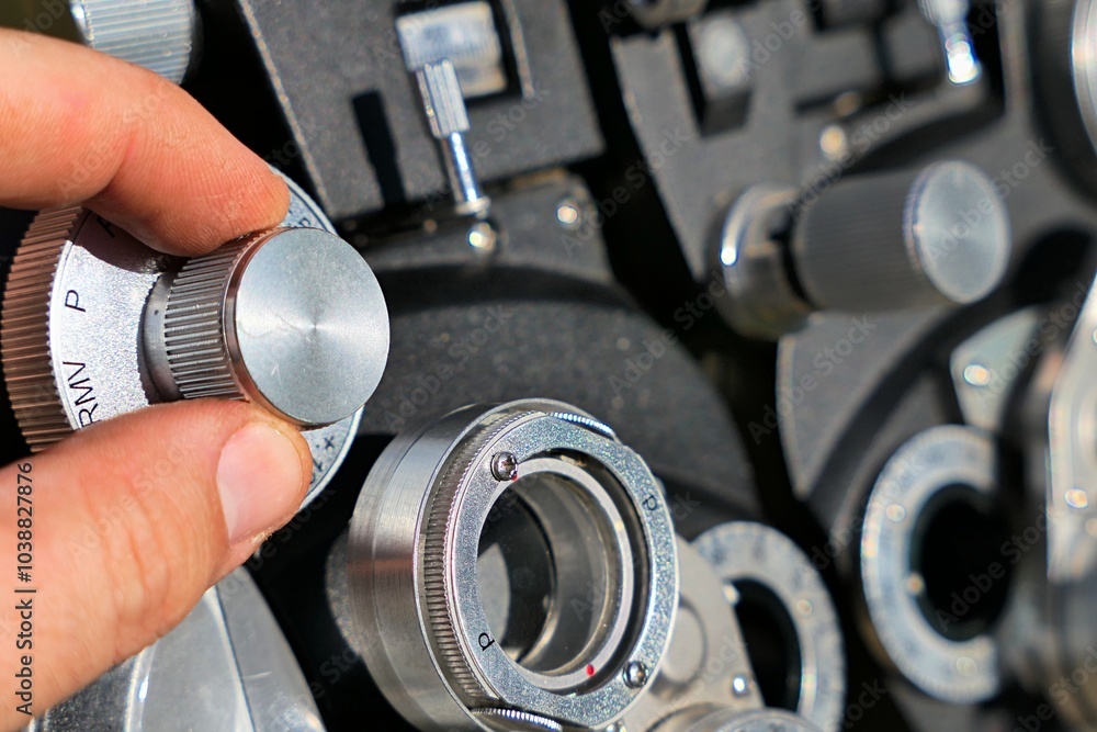 Hand of optometrist setting spherical values on rotary knob on old ...