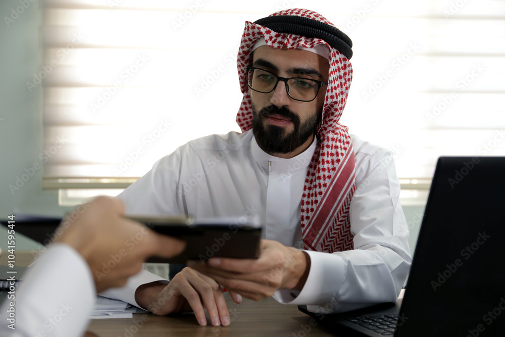 Arab man review documents in workplace Stock Photo | Adobe Stock
