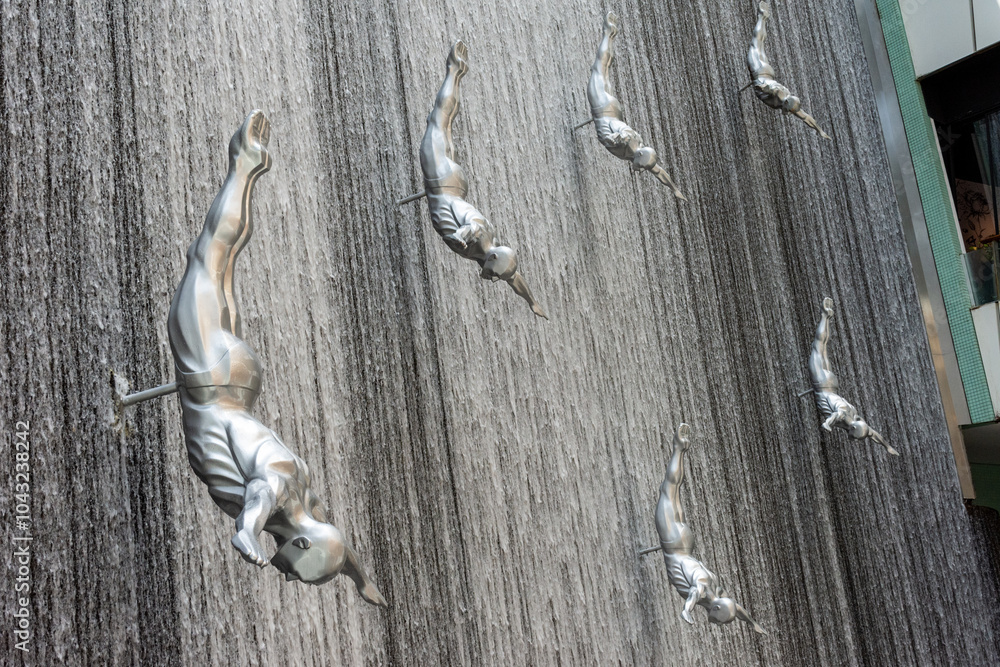 Diving men's sculptures of the iconic waterfall of the Dubai Mall ...