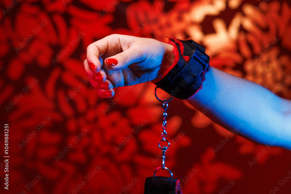 Soft BDSM handcuffs adorn a womans hands with alluring red nails The ...