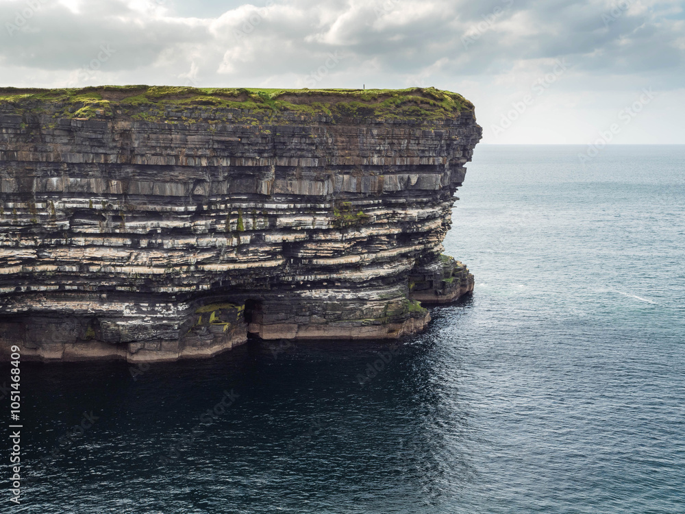 Rough stone coast line with cliff and blue ocean and blue sky ...