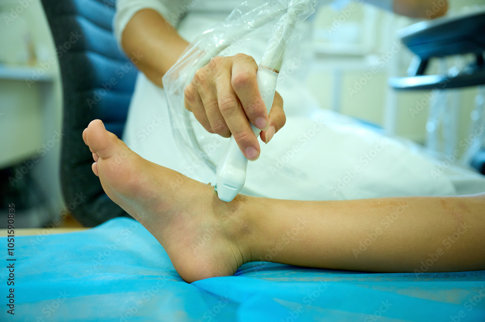 Pediatric ultrasound scan. Child ultrasound. Pediatrician scanning feet ...