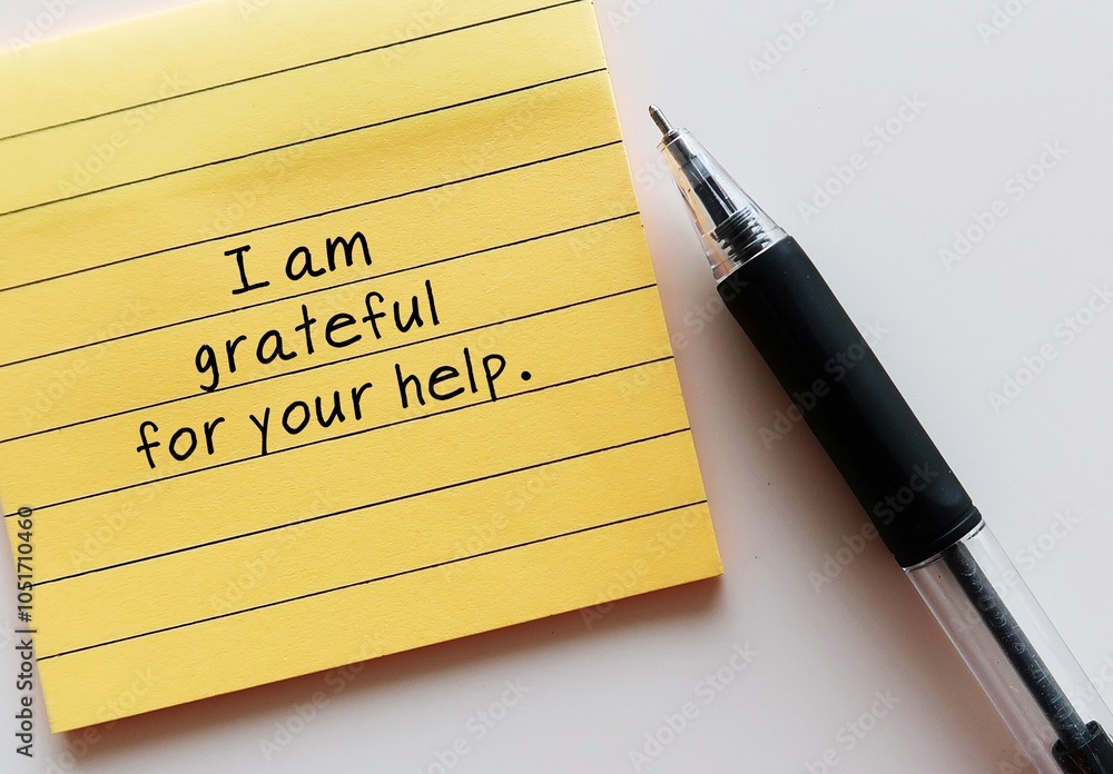 Paper yellow note with text written - I am grateful for your help ...