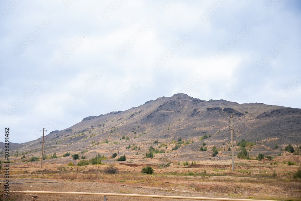 50-meter industrial metal production waste heap with trees and bushes ...